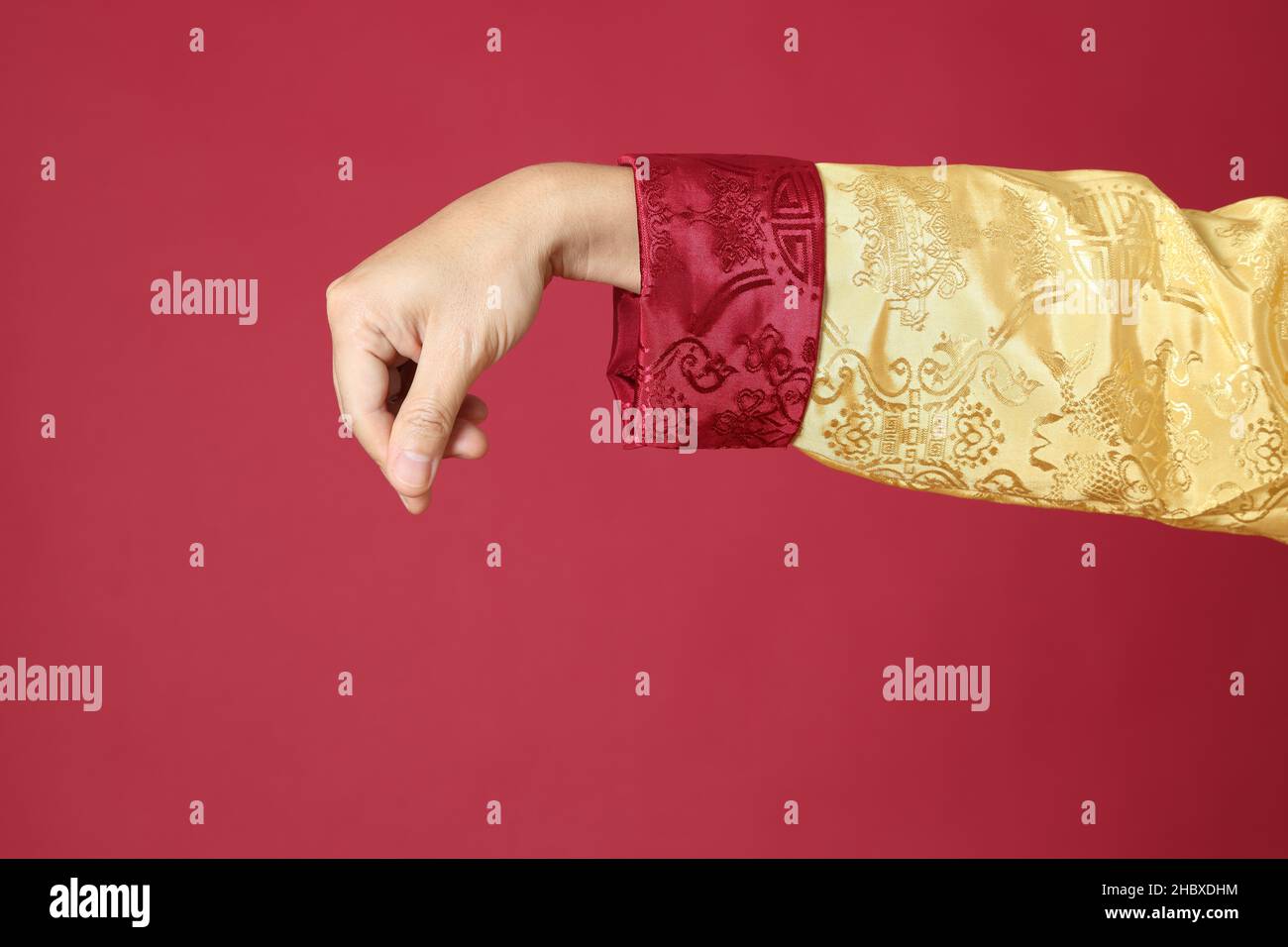 The Chinese man hand with tradion dressed on the red background Stock ...