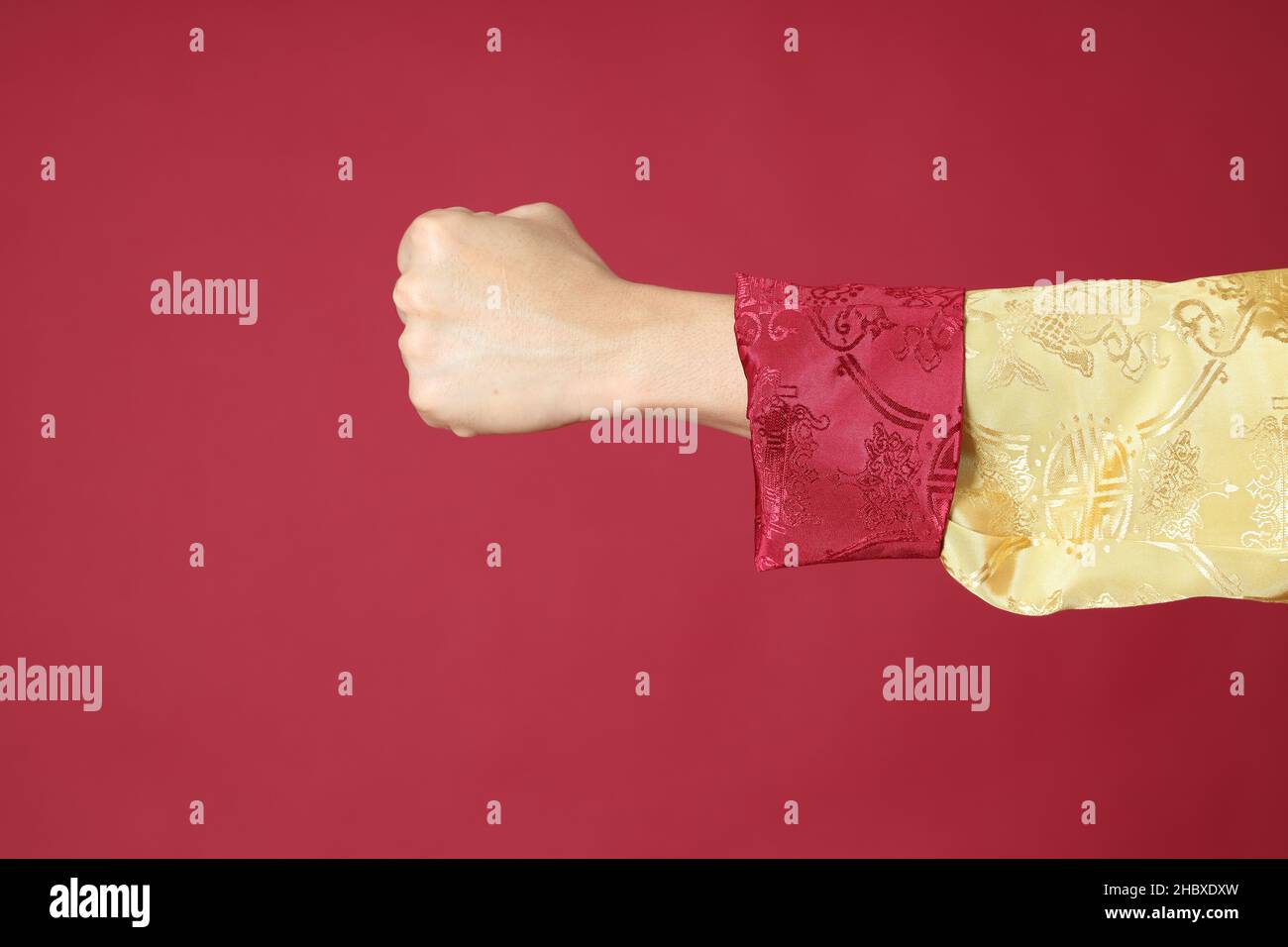 The Chinese man hand with tradion dressed on the red background Stock ...