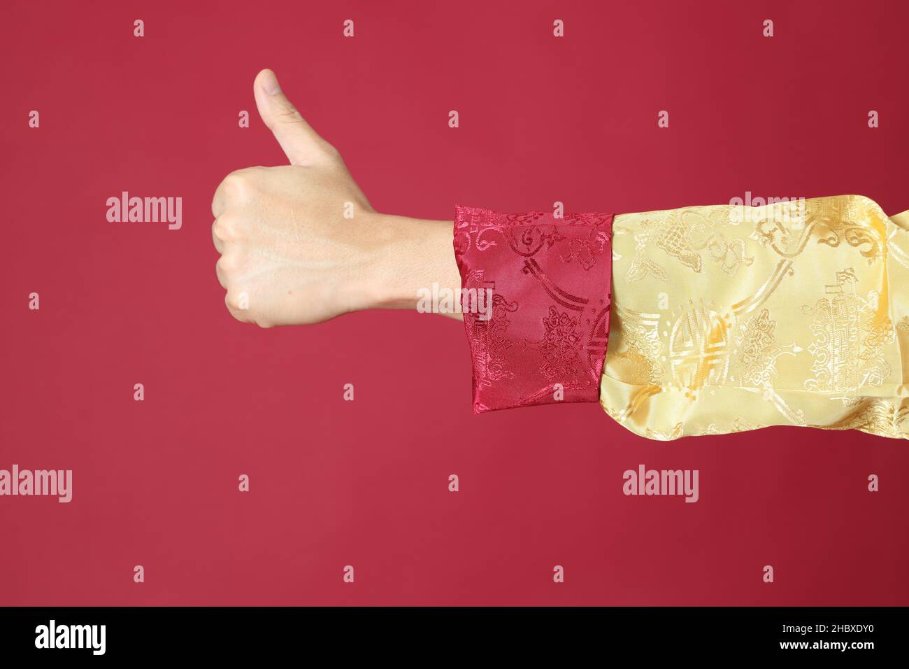 The Chinese man hand with tradion dressed on the red background Stock ...