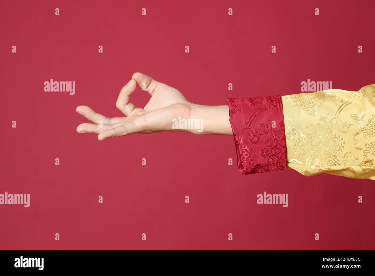 The Chinese man hand with tradion dressed on the red background Stock ...