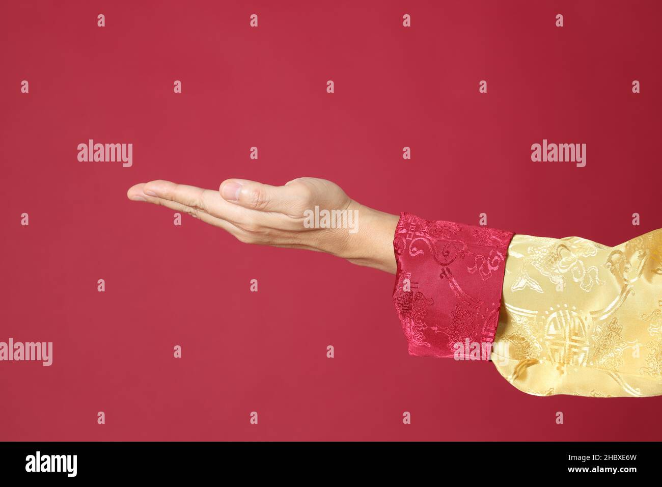 The Chinese man hand with tradion dressed on the red background Stock ...