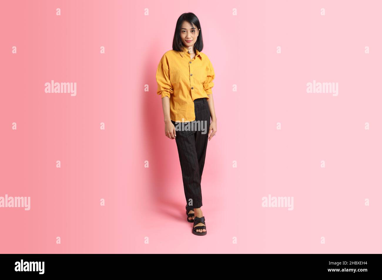 The mixed race woman standing on the paink background Stock Photo - Alamy