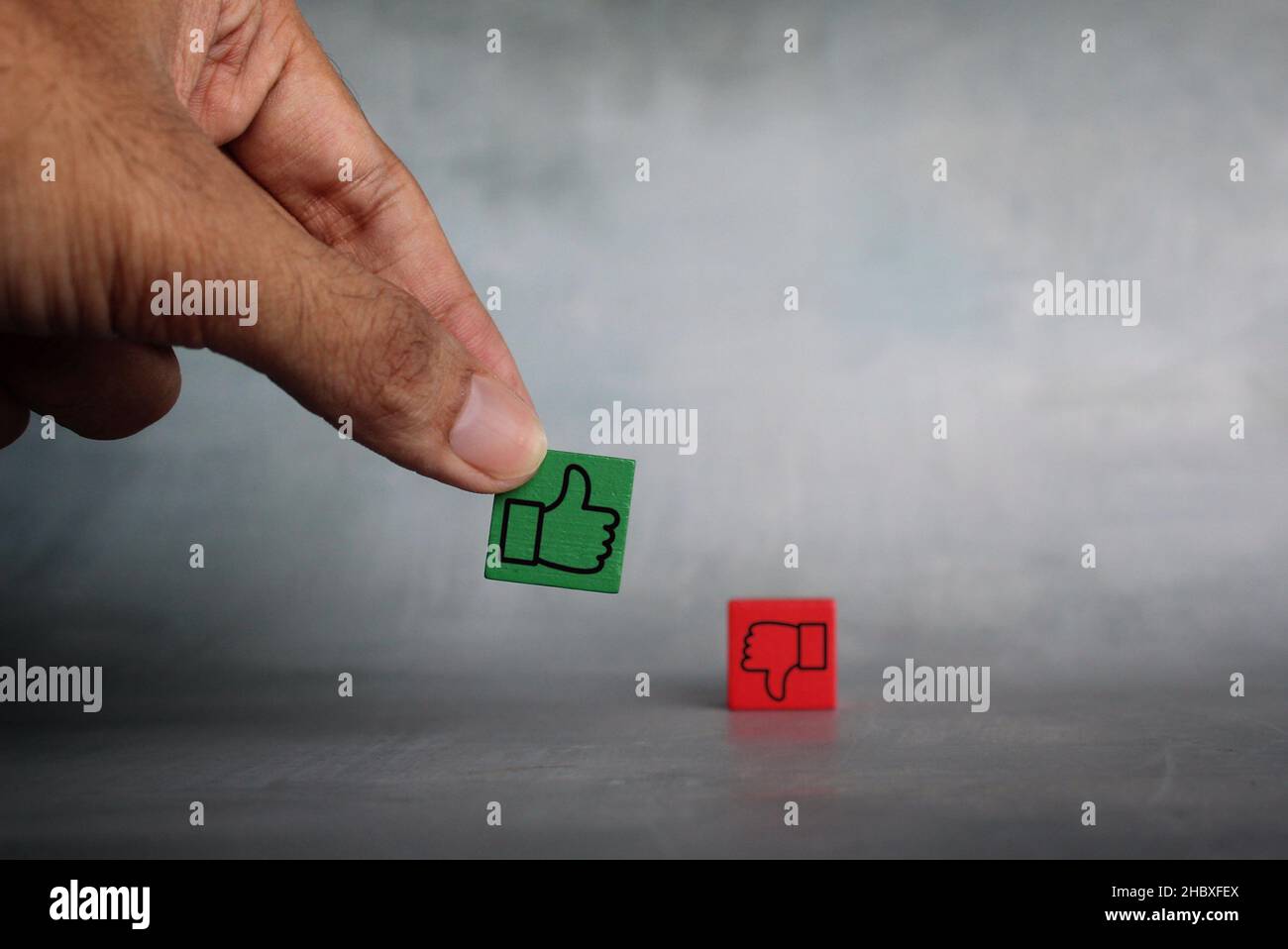 Feedback and review concept. Hand pick wooden cube with thumbs up icon ... Feedback and review concept. Hand pick wooden cube with thumbs up icon ...