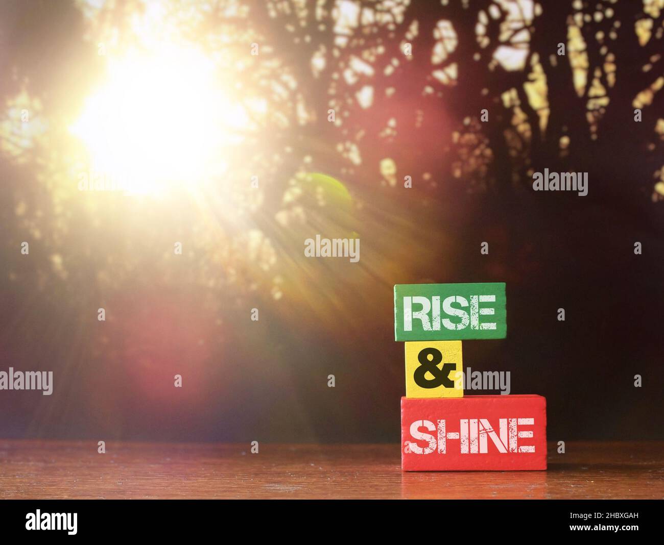 RISE AND SHINE written on wooden tiles with background of bokeh sunrise ...