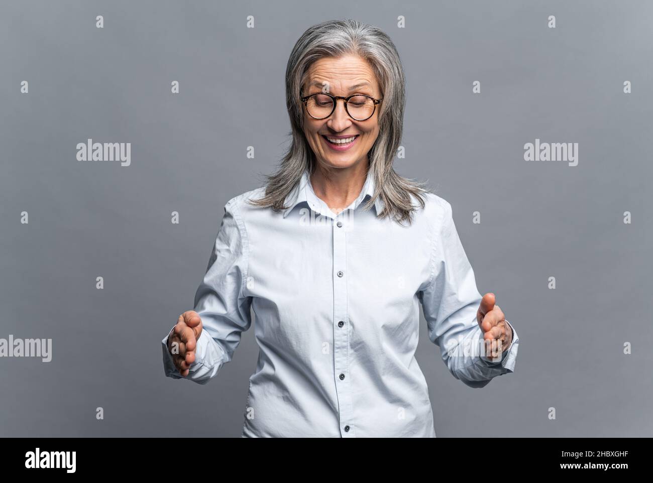 Senior mature gray-haired businesswoman showing with hands length ...