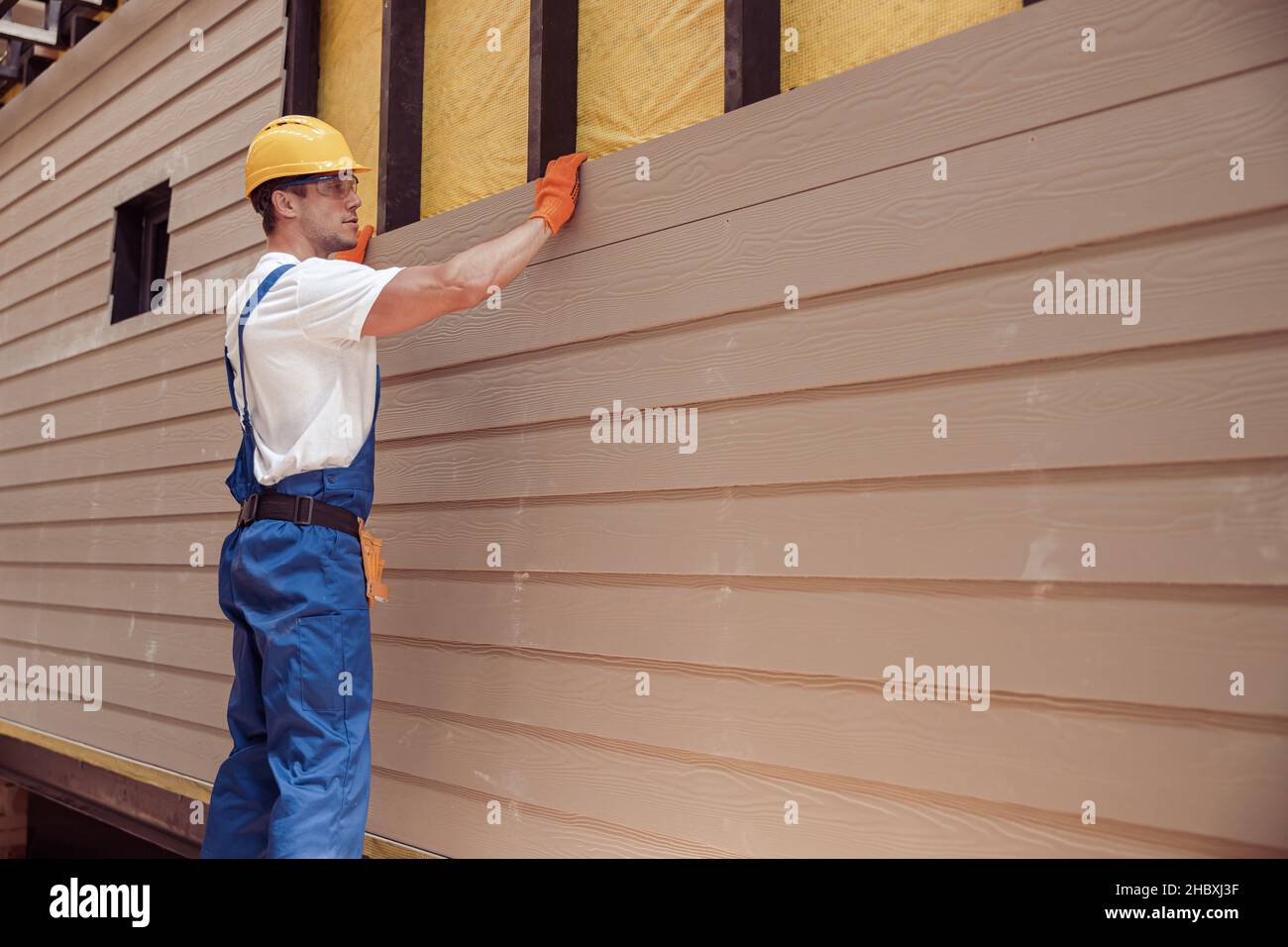 Male worker building house at construction site Stock Photo - Alamy