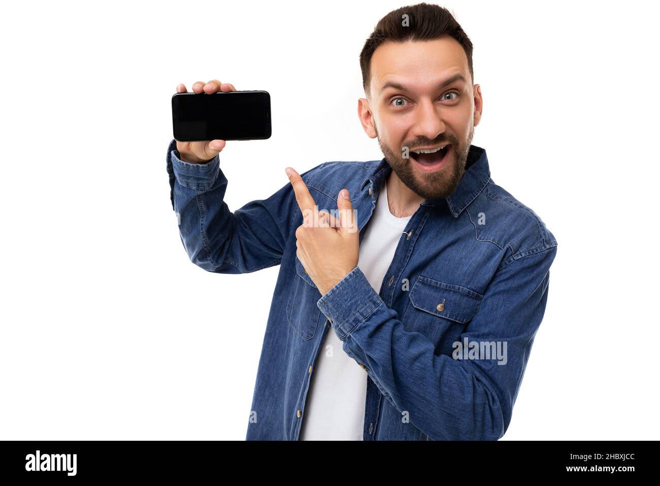 handsome young man points finger at smartphone screen with with ...