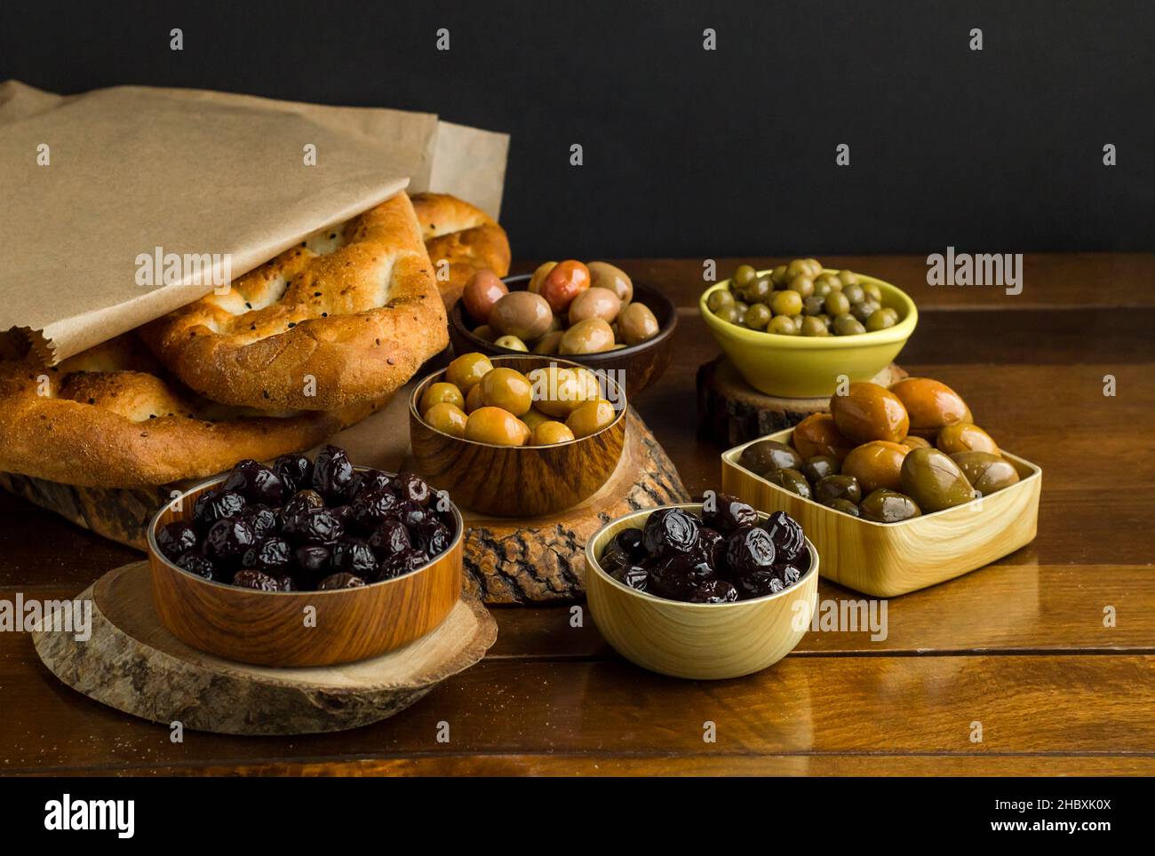 Fresh Ramadan breads in craft paper on wooden table with olive ...