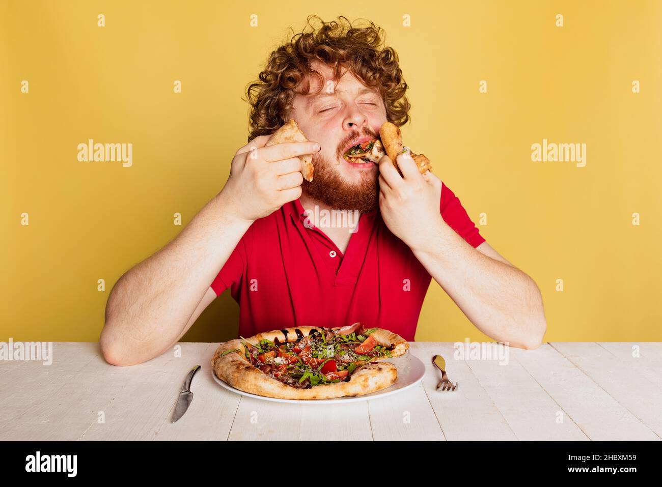 Portrait of red- bearded man tasting delicious Italian pizza isolated ...