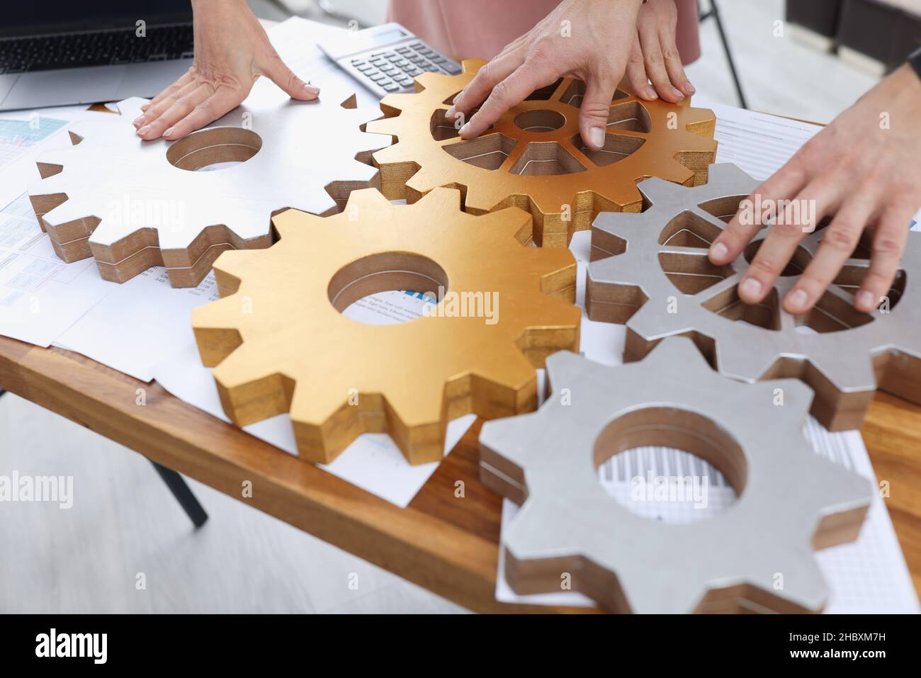 Businessmen are stacking gold and silver gears Stock Photo - Alamy