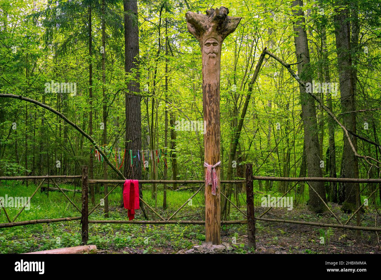 Slavic neopagan forest temple with a carved deity Veles in a forest ...
