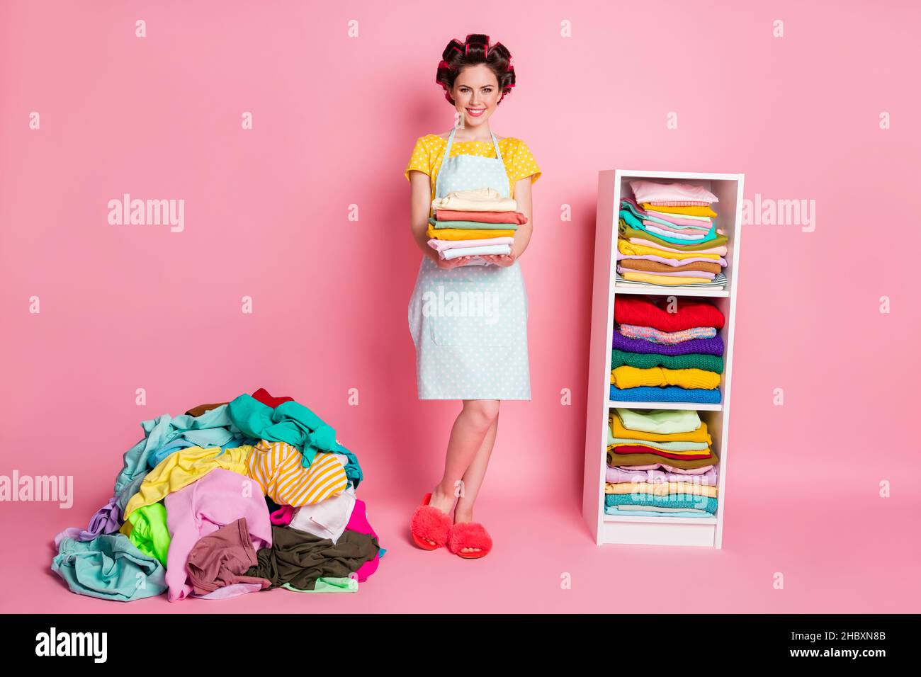 Full length photo positive girl hold pile heap clothes many huge mess ...