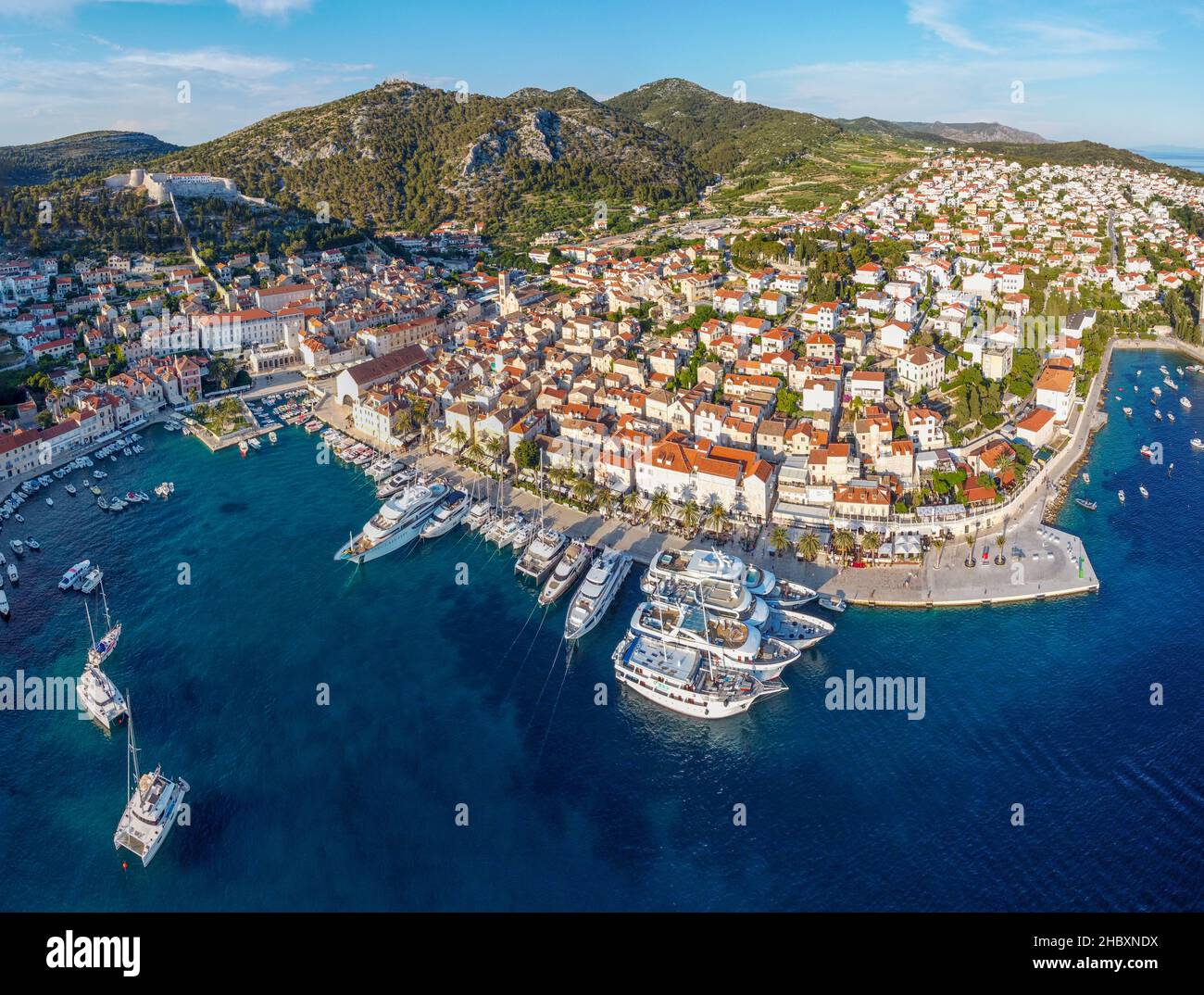 Streets of historic and tourist town of Hvar with fort, port and yacht ...