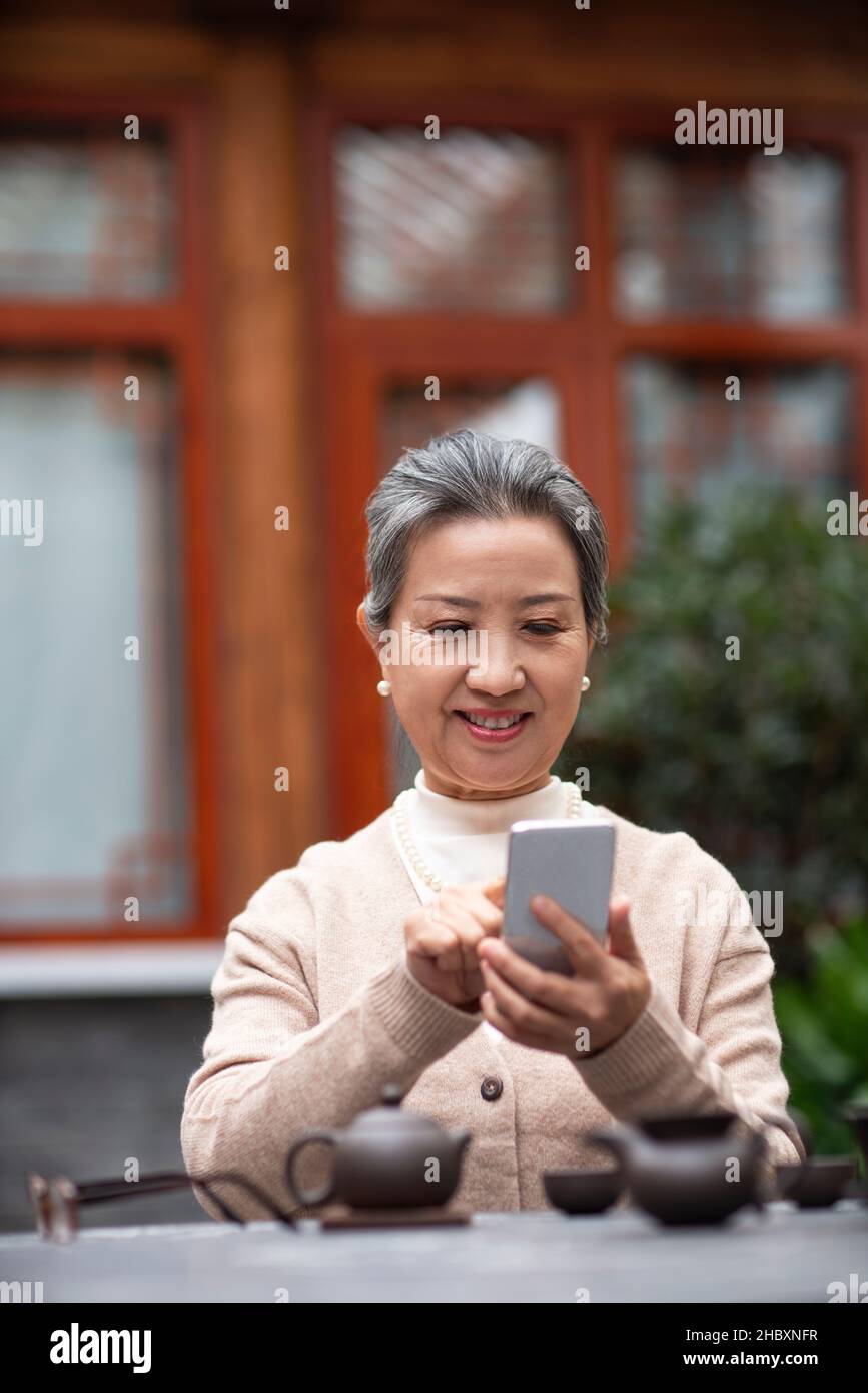 Old woman using a smartphone Stock Photo - Alamy