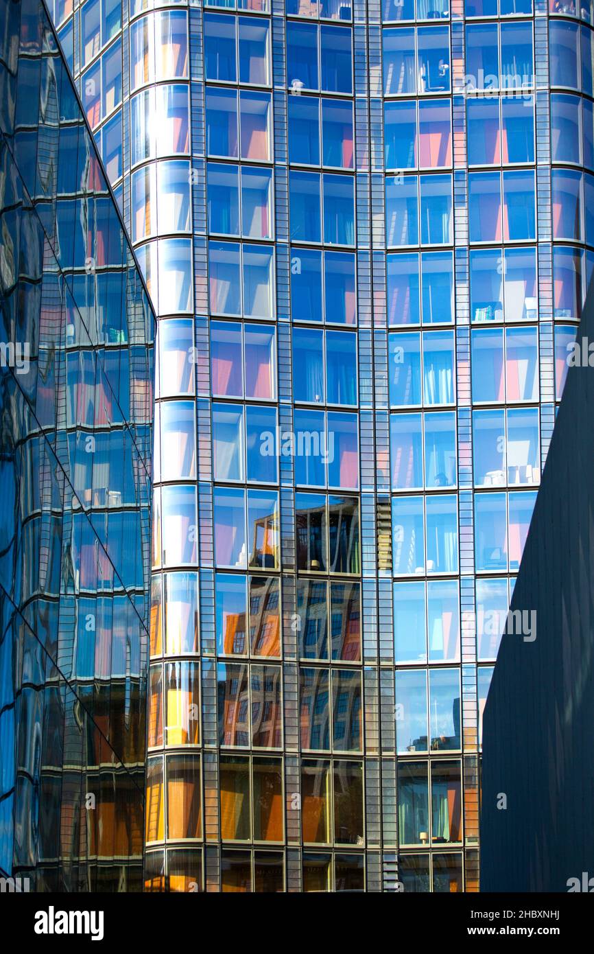 London city buildings and blue sky reflected in large glass building ...