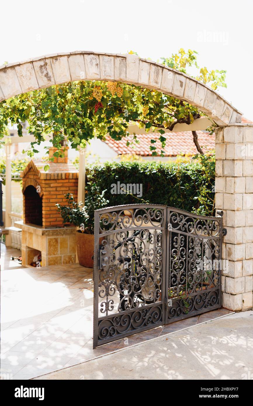 Forged metal gate in a brick fence of a private courtyard Stock Photo ...