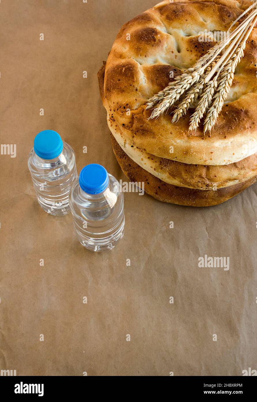 Fresh Ramadan Breads stacked on craft paper surface with two bottle of ...