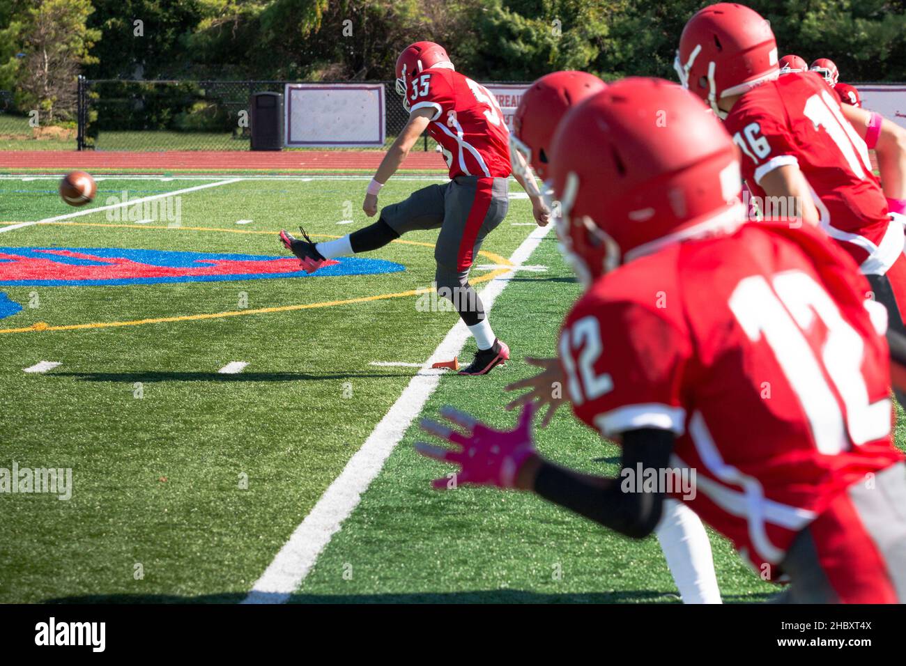 The football team starting to run down the field as the kicker kicks ...