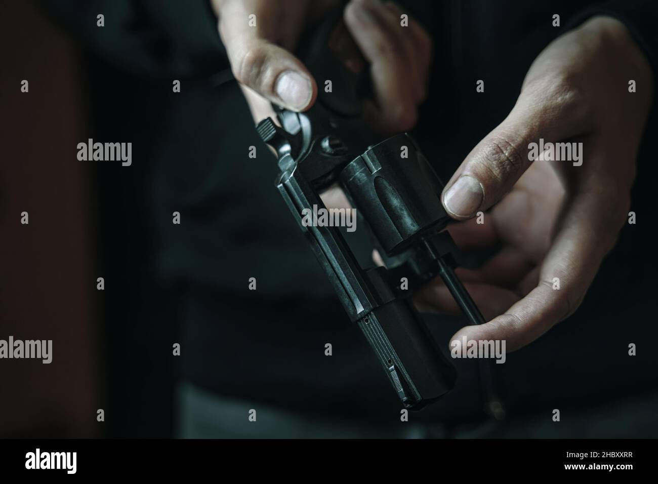 Men's hands check for bullets in revolver barrel Stock Photo - Alamy