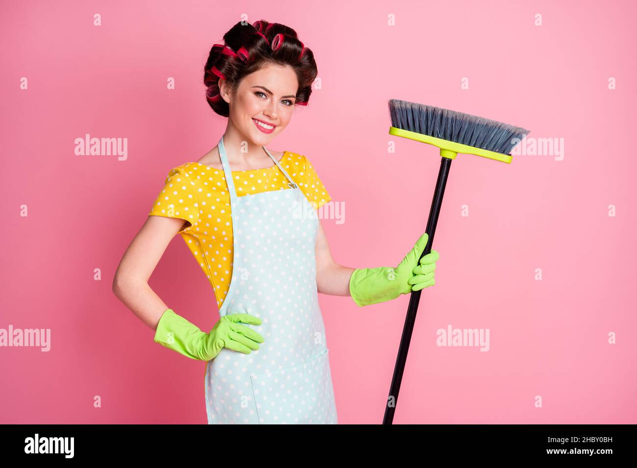 Portrait of pretty cheerful experienced maid doing tidy-up cleanup ...
