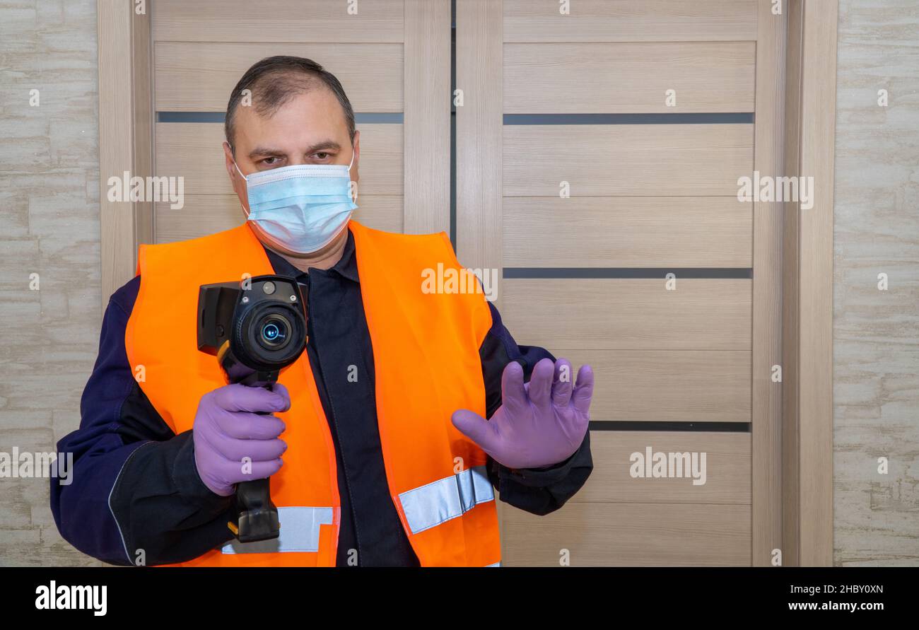 guard checks the temperature with a thermal imager when entering the ...