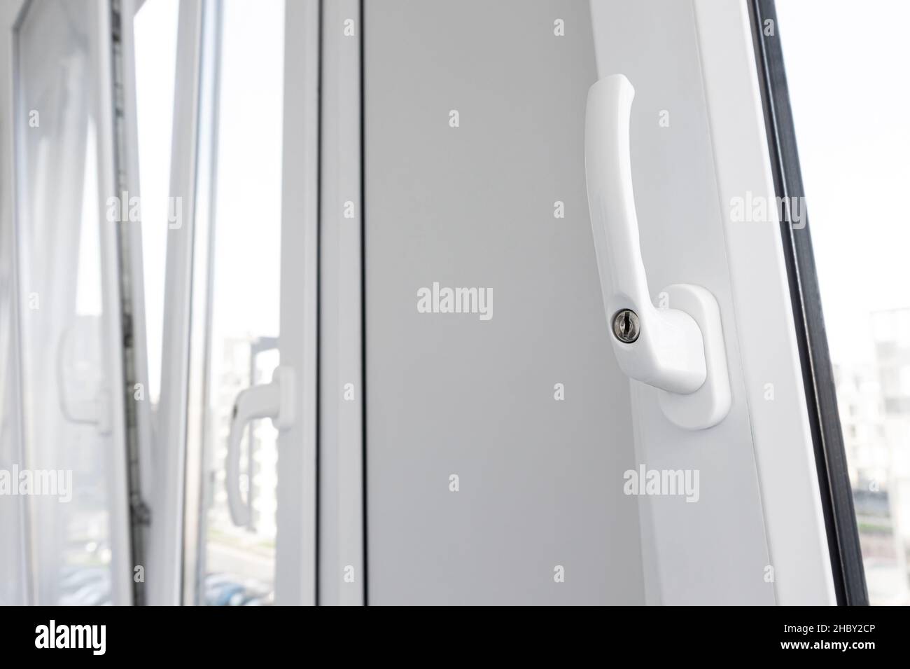 Opened white plastic window handle in upright position close-up. New ...