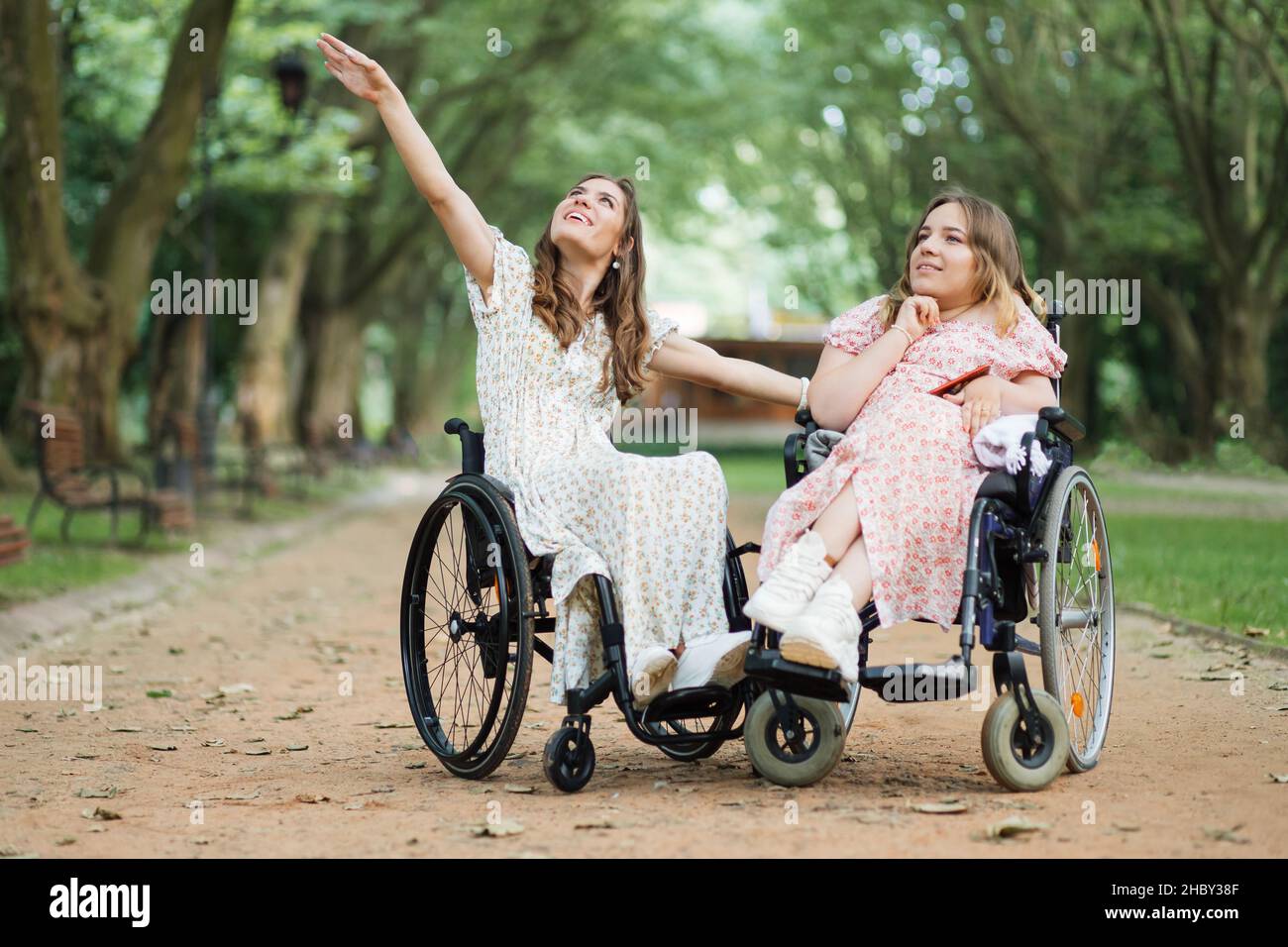 Pleasant young women with disability smiling and taking fun during ...