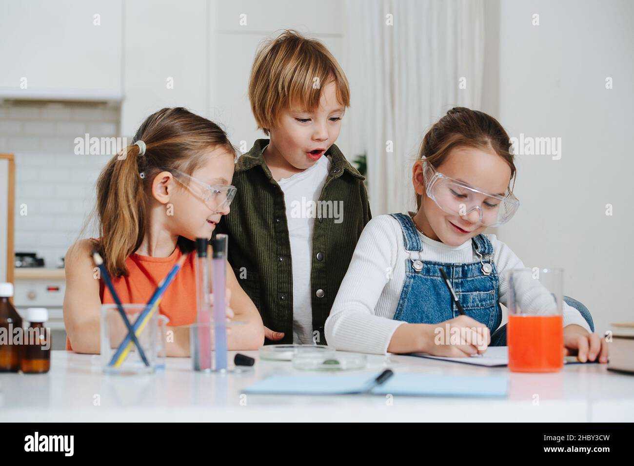 Happy little kids doing home science project, girl is documenting the ...