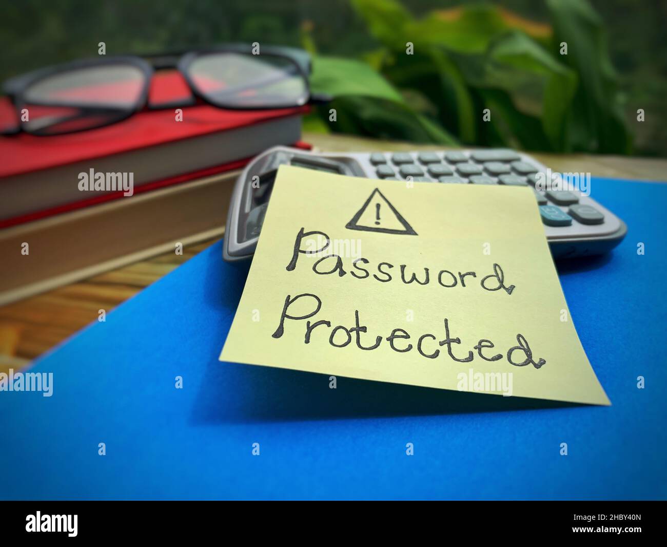 Password protected text written on a sticky note with books and ...