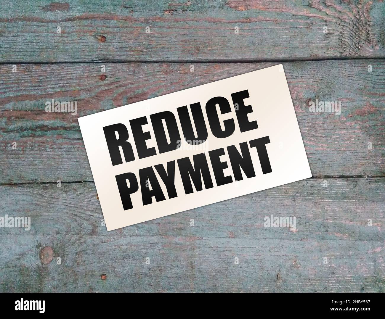 Reduce payment text on card on wooden background. business concept ...