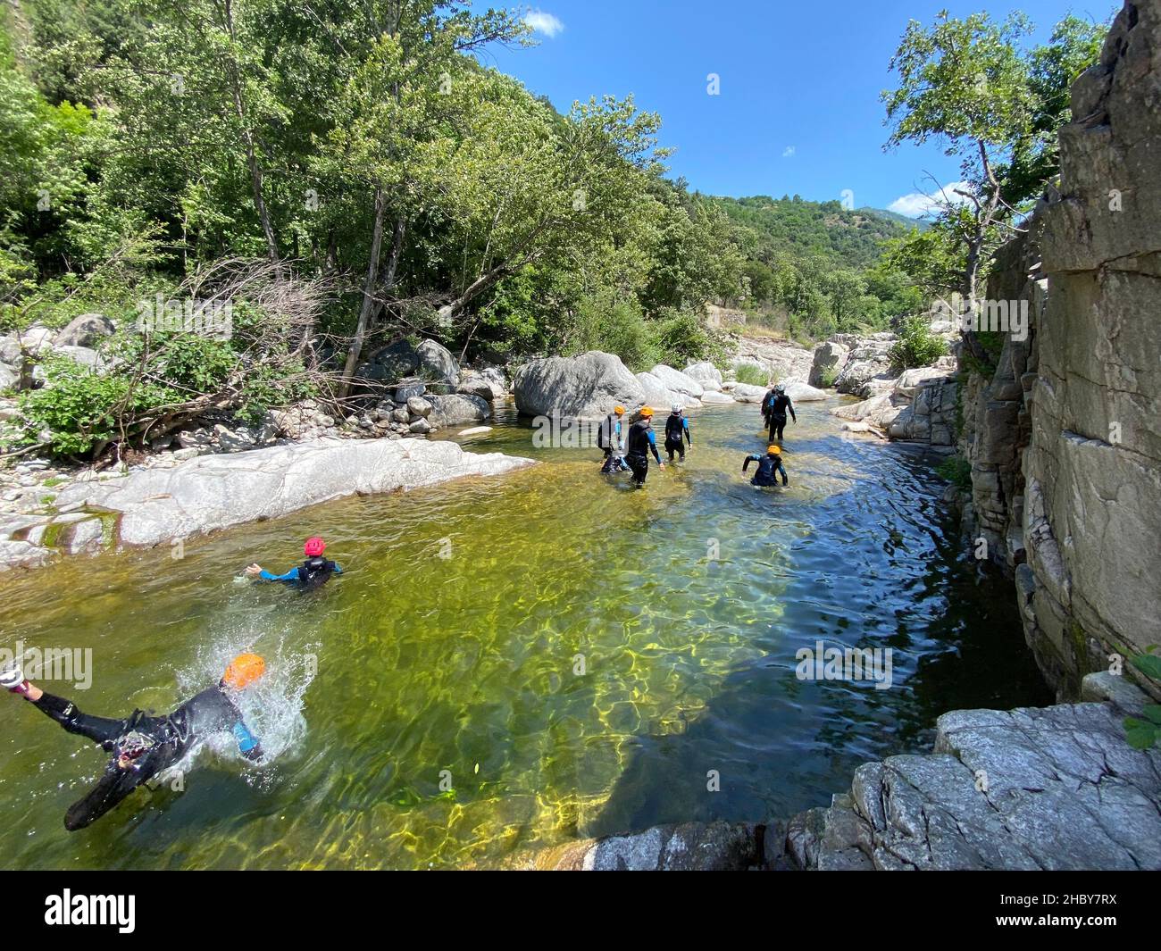 Back view of a group of people who are canyoning in Chassezac river in ...
