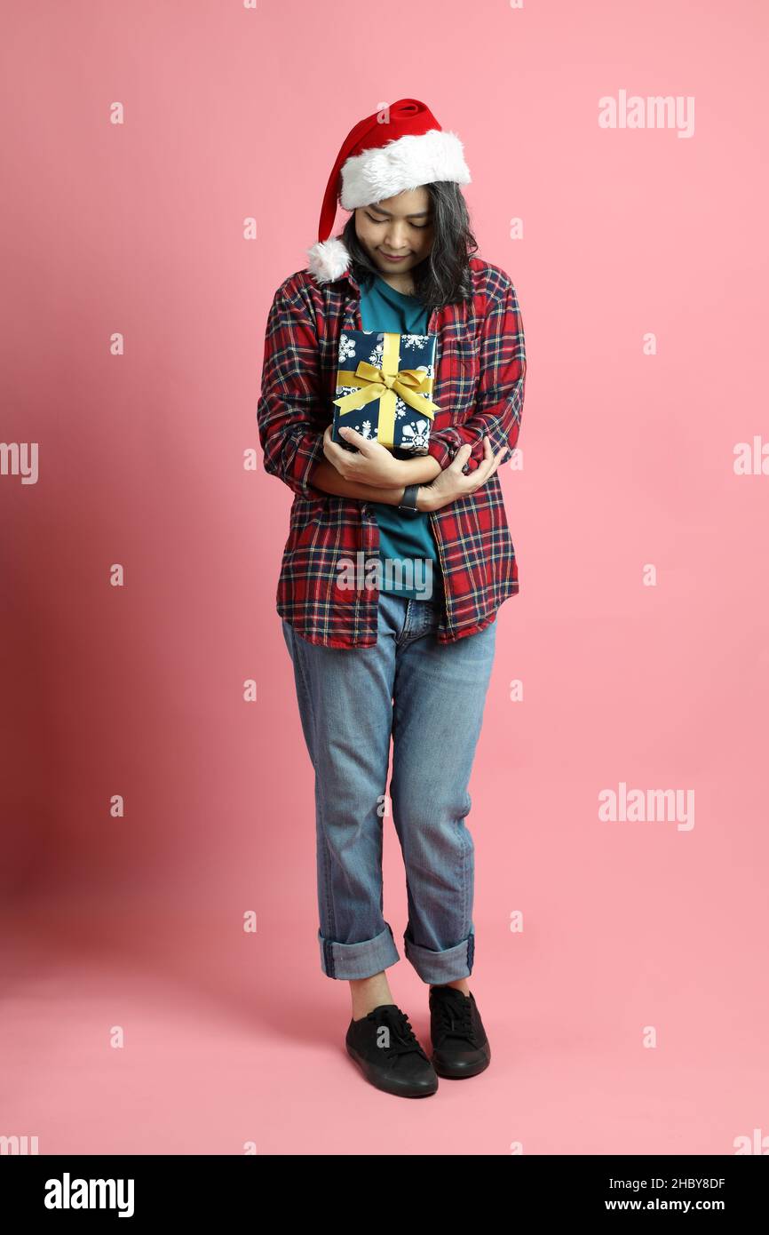 The Asian woman with santa hat standing on the pink background Stock ...