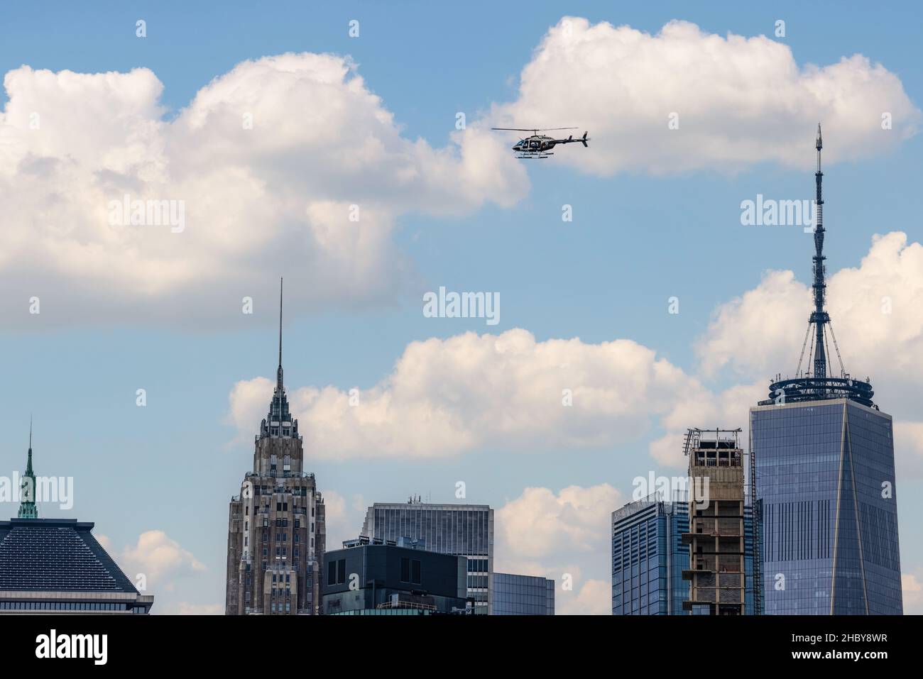 A helicopter flying in the cloudy sky above the buildings in New York ...
