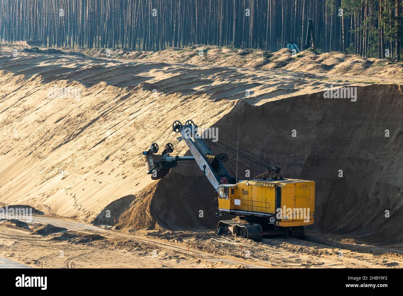 Heavy excavator in sand quarry, mining industry Stock Photo - Alamy
