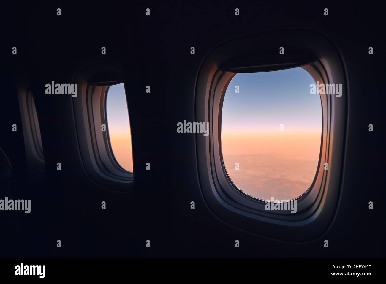 Windows of airplane during flight above clouods at beautiful sunrise ...