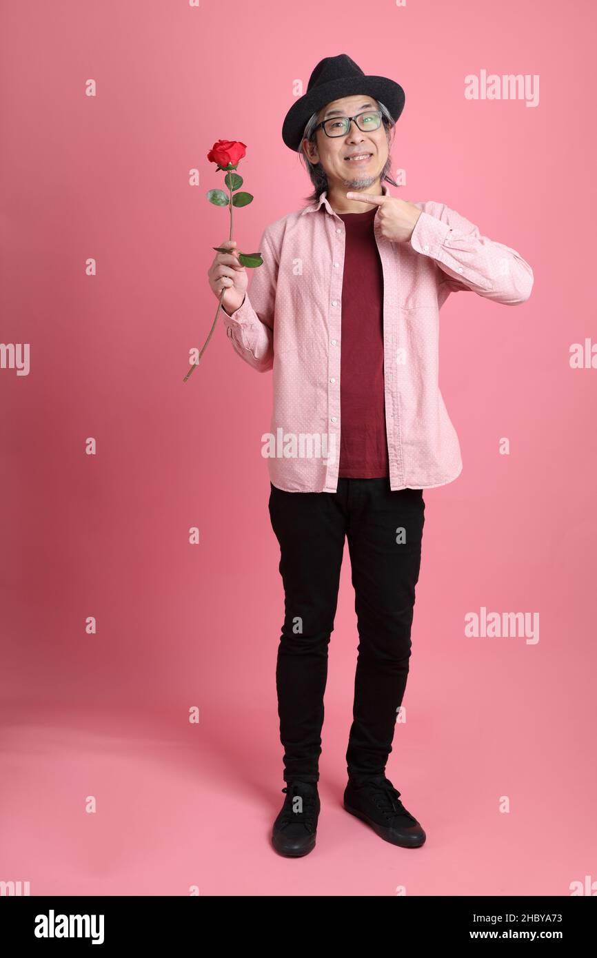 The senior Asian man standing on the pink background Stock Photo - Alamy