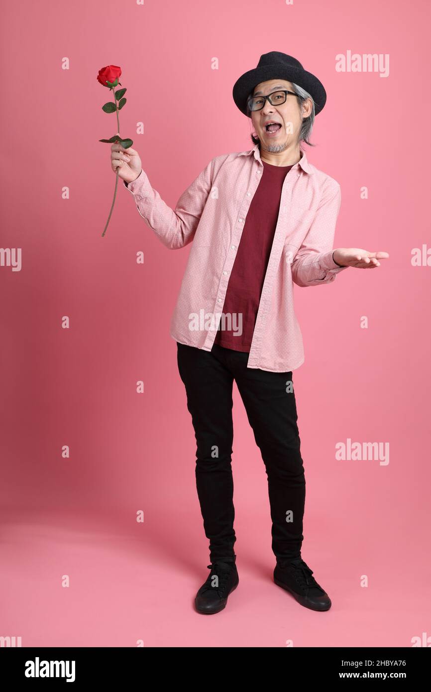 The senior Asian man standing on the pink background Stock Photo - Alamy