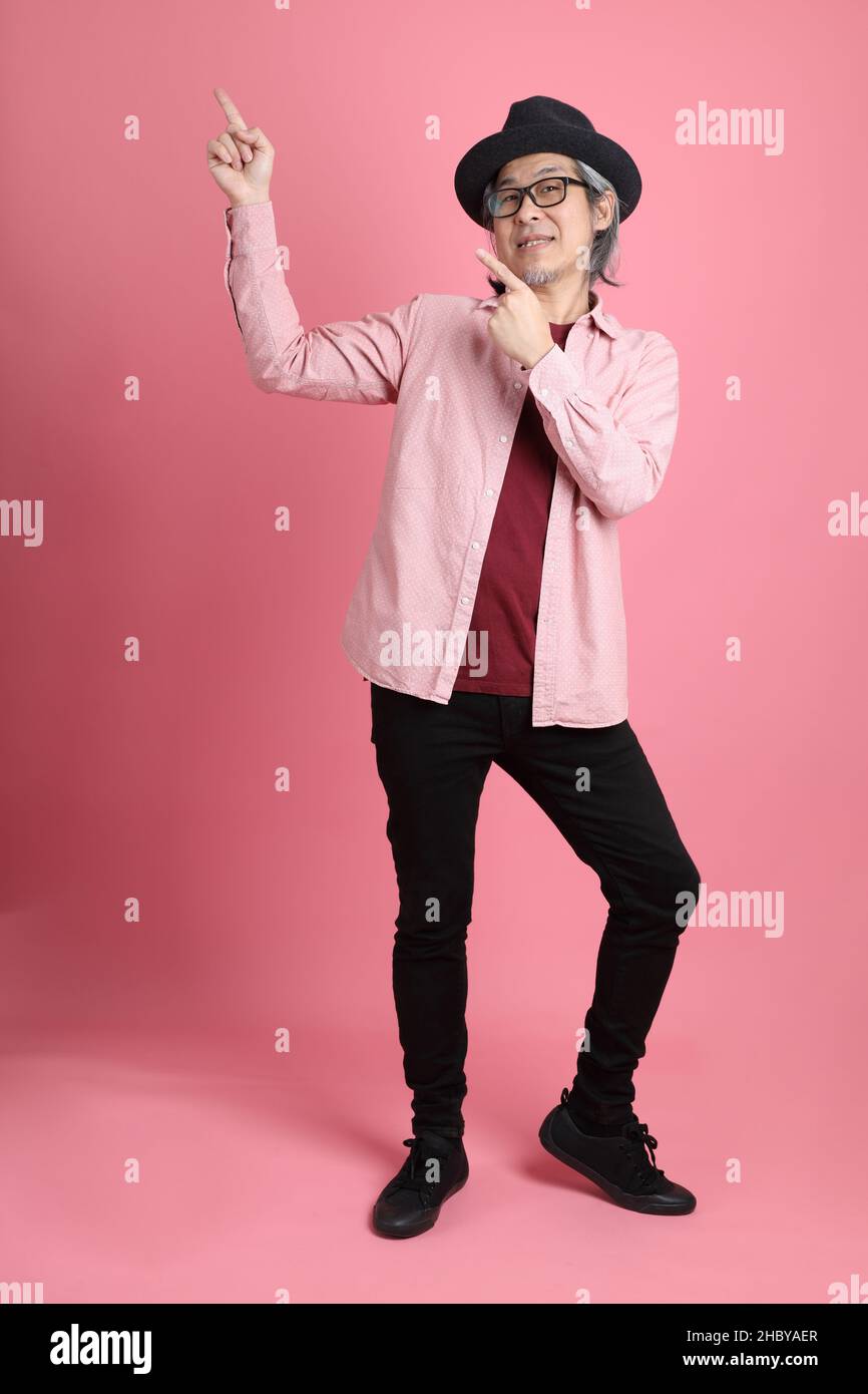 The senior Asian man standing on the pink background Stock Photo - Alamy