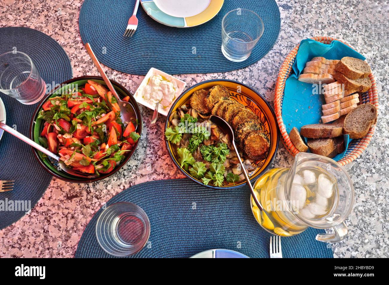 Salad plate with mixed salads on table with sets and bread basket Stock ...