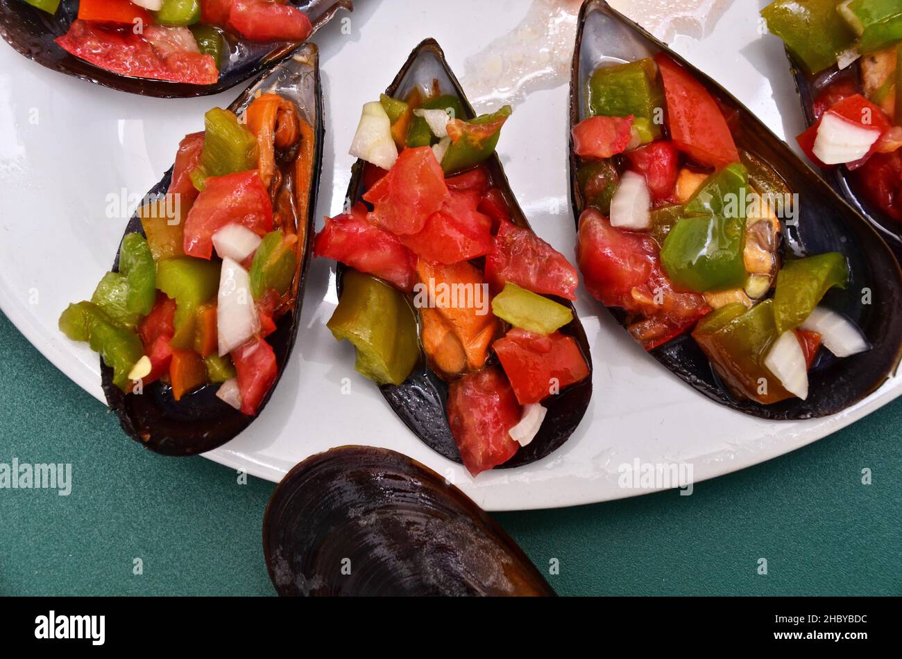 Stuffed mussel halves with chopped peppers, onions and mussel meat, top ...