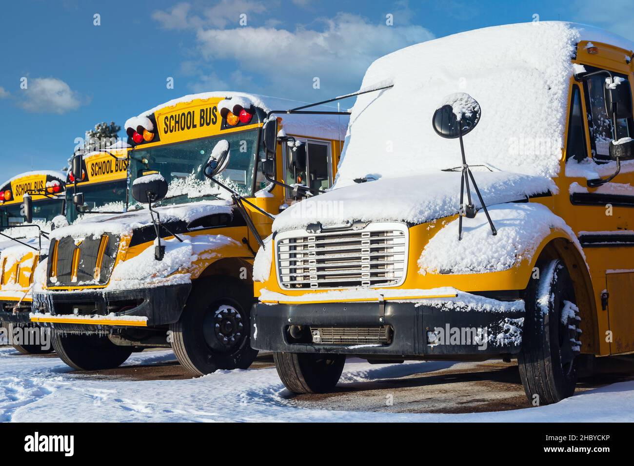 Snow covered school buses parked in a school parking lot Stock Photo ...