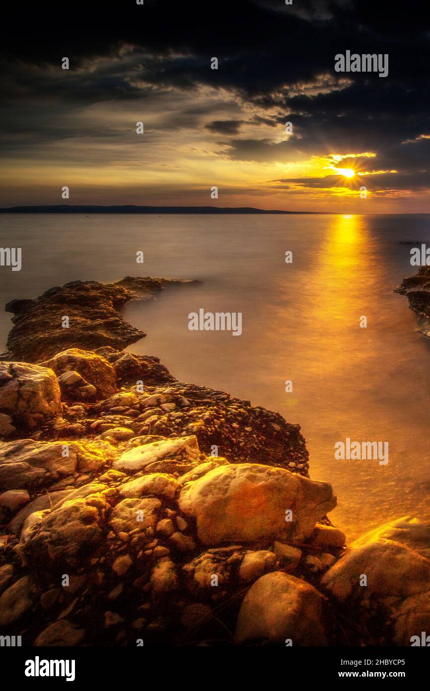 A vertical shot of the scenic view of the river at the beautiful sunset ...