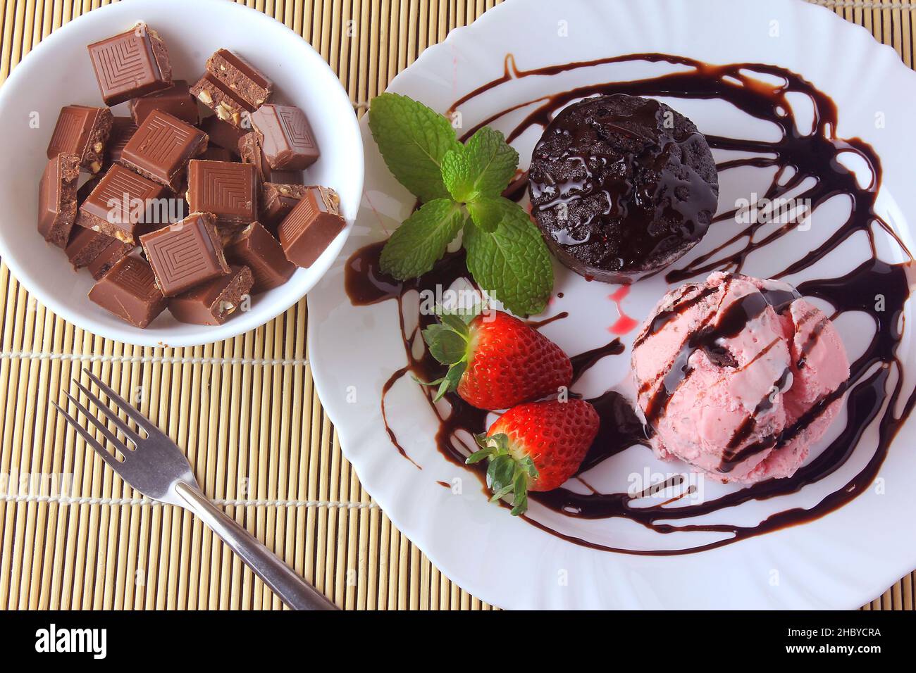 petit gateau dessert with ice cream on white plate with strawberry over ...