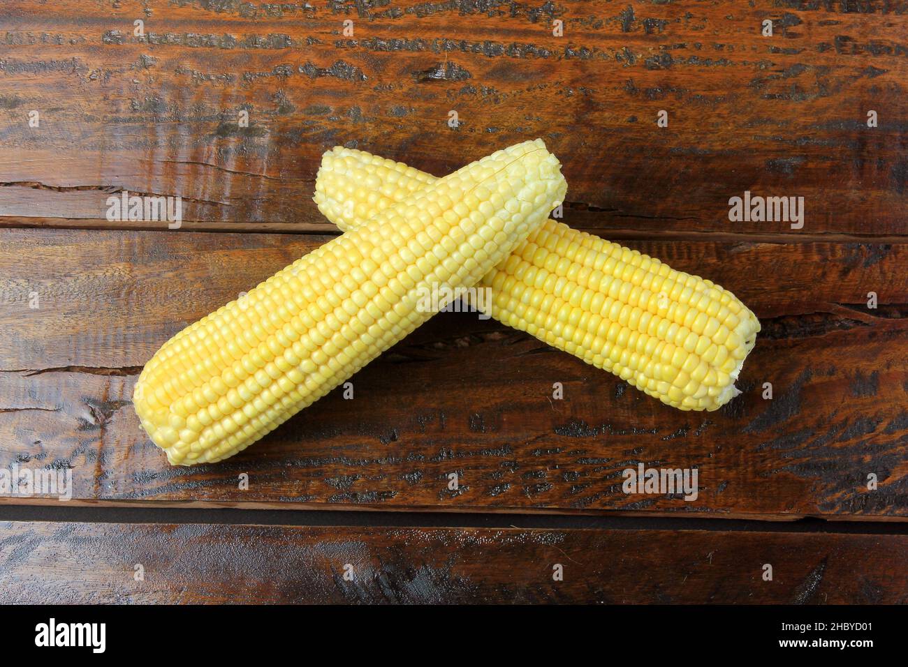 raw corn cob, harvested from plantation, on rustic wooden table. space ...