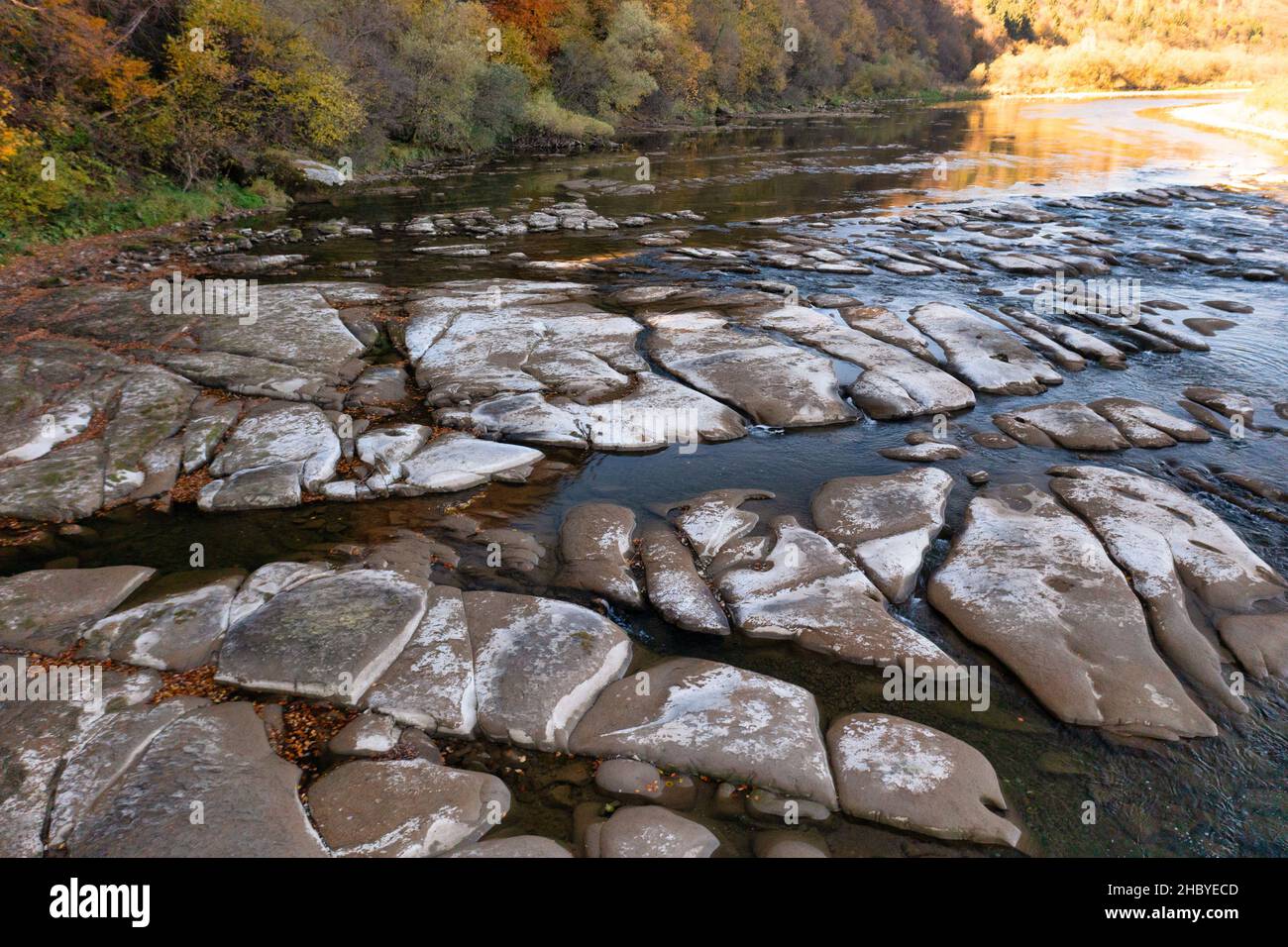 Long rocky river stream with rapids at foothill of high mountain with ...
