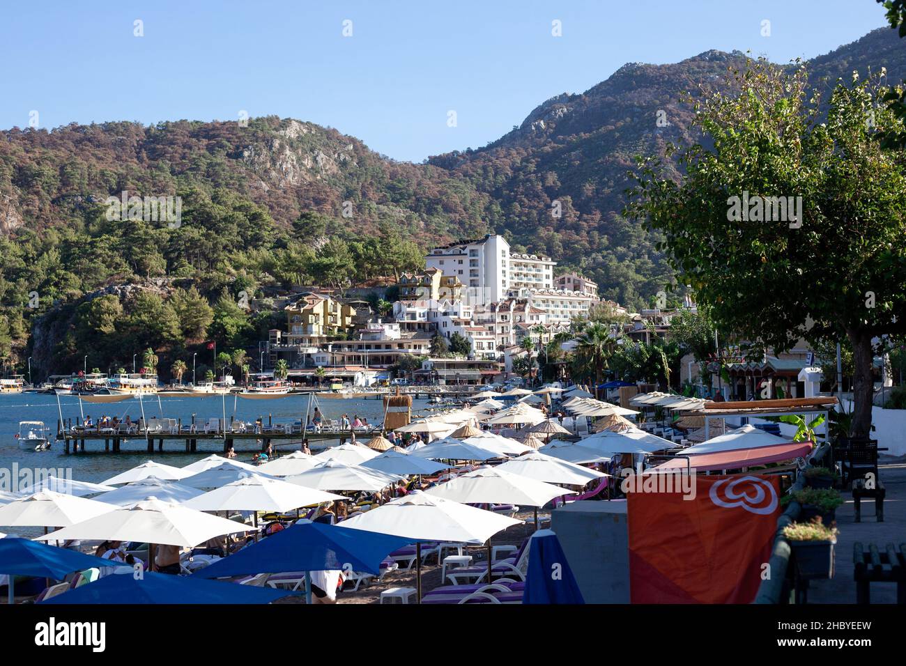 Crowded beach in touristic resort village in Turkey. Small picturesque ...