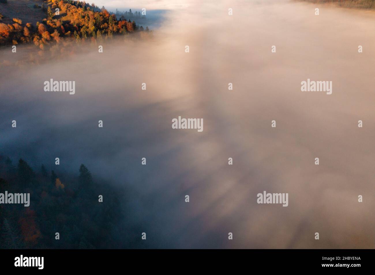 Thick layer of fog covering rainbow high mountains with terracotta and ...