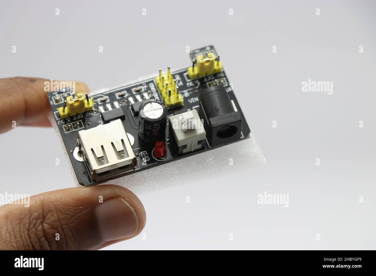 Breadboard power supply module held in hand isolated on white ...