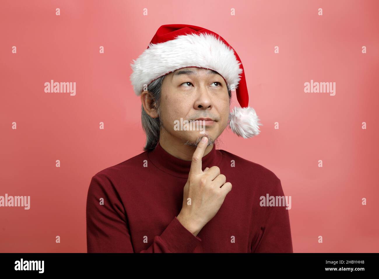 The Asian man portrait with santa claus hat on the pink background ...