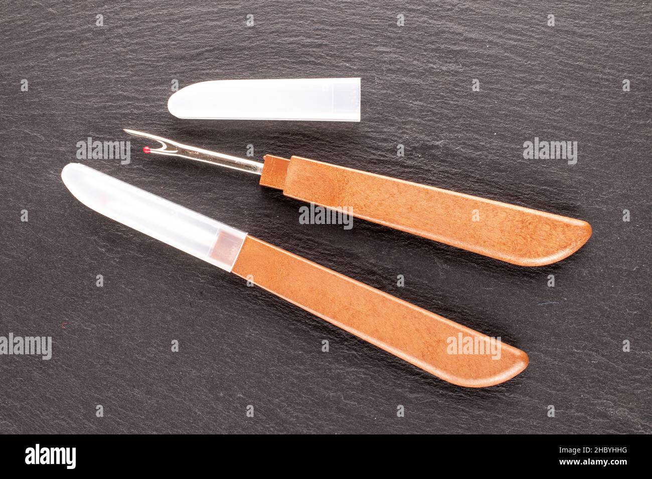 Two sewing knives for cutting threads on a slate stone, close-up, top ...